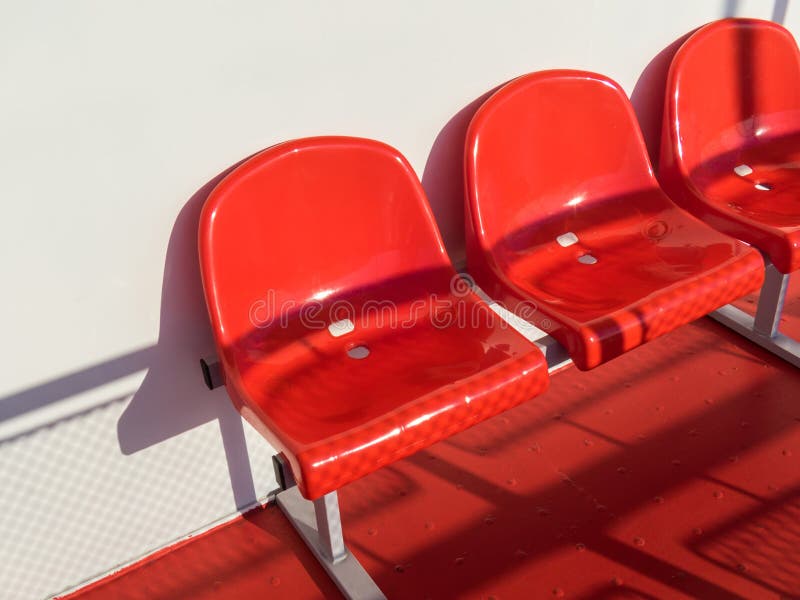 Red Plastic Chairs in Front of a White Wall Stock Image - Image of wall ...