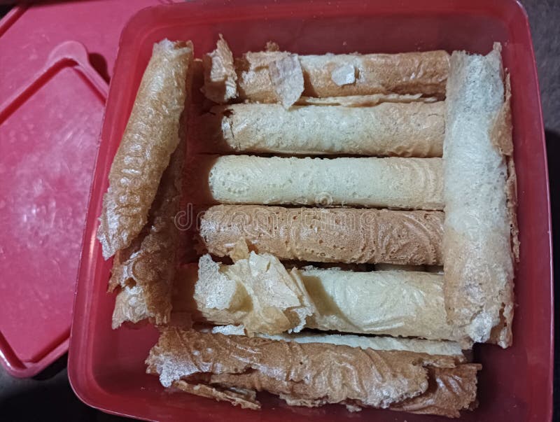 A Red Plastic Container Filled with Crispy Rolled Wafer Cookies Stock ...
