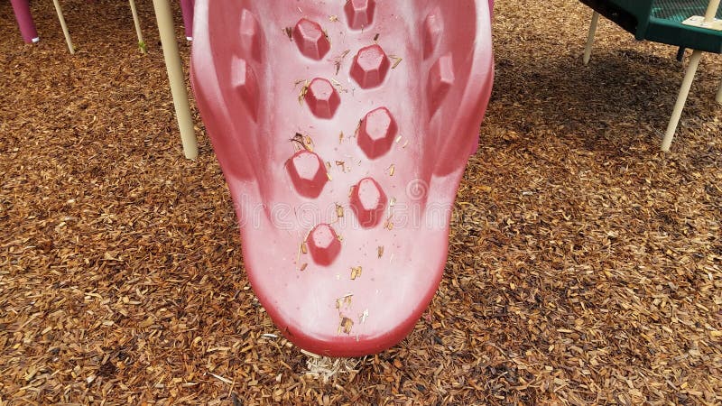 Red Plastic Playground Slide with Wood Chips on Ground Stock Image ...