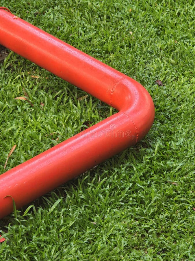 Red Plumbing Pipe at the Garden with Green Grass Stock Photo - Image of ...