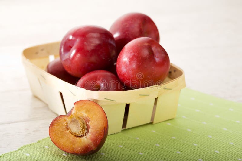 Red plums in small basket stock image. Image of market - 4648673