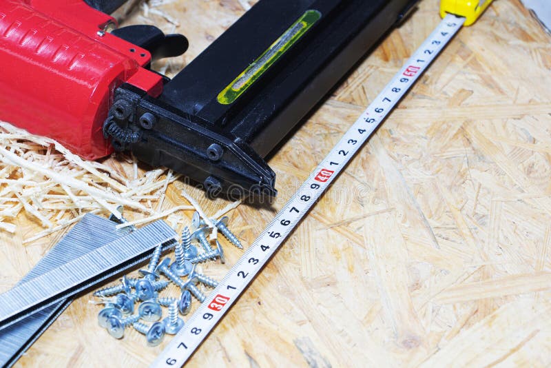 Red Pneumatic Construction Stapler and a Stack of Staples for the ...