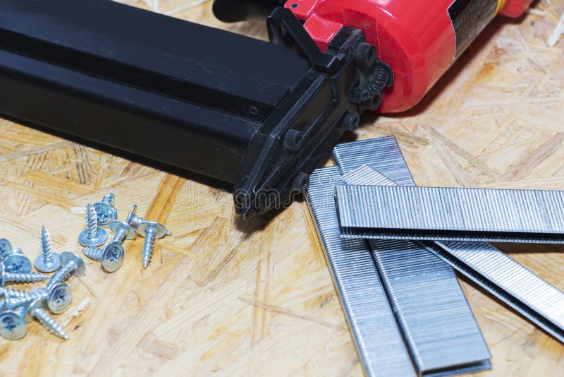 Red Pneumatic Construction Stapler and a Stack of Staples for the ...