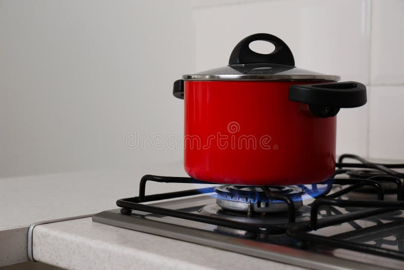 Red Pot on Stylish Kitchen Stove with Burning Gas, Space for Text Stock ...