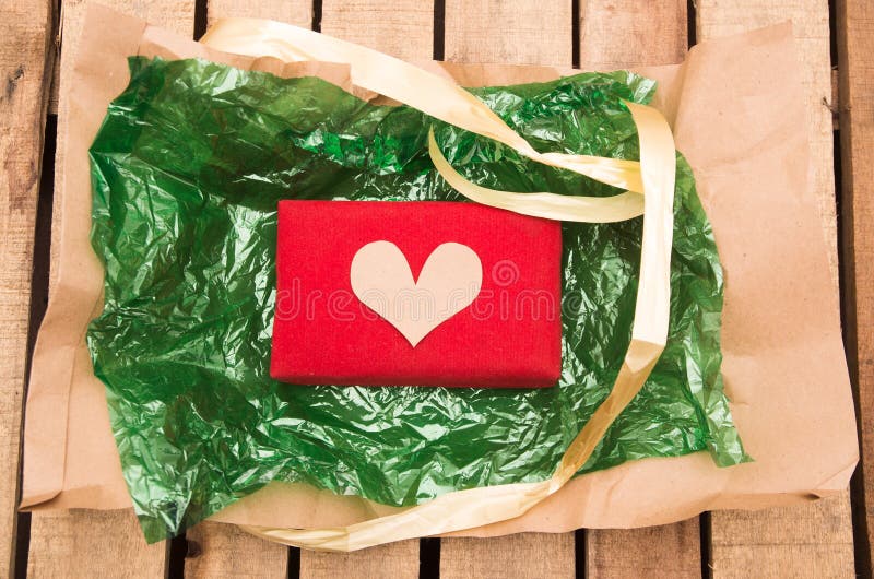 Red Present Lying on Green Plastic with Golden Ribbon String Around it ...
