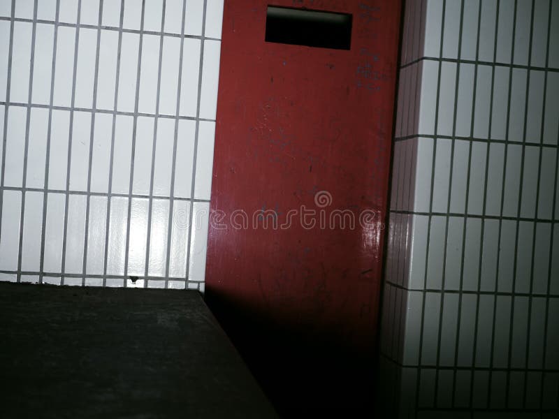 Red Prison Door Closed in White Tile Prison Cell Medium Shot Stock ...