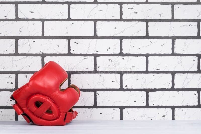 Red Protective Helmet for Boxing Lies on a Light Floor Against a Brick ...