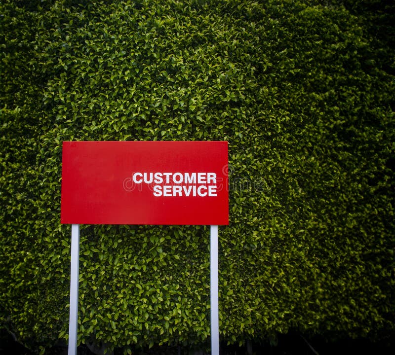 A Red Rectangular Customer Service Sign on White Poles with White ...
