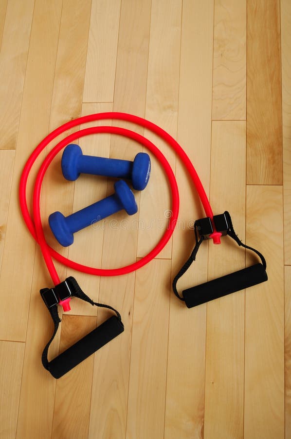 Red Resistance Band and Blue Weights on Gym Floor Stock Photo - Image ...