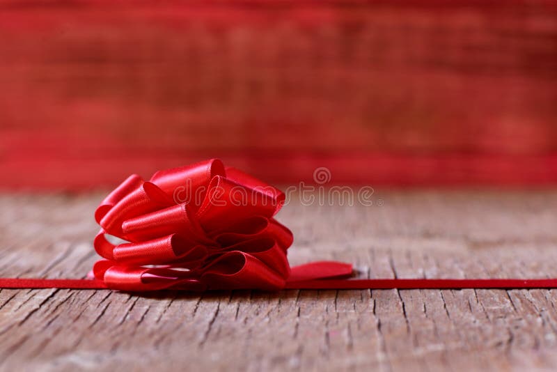 Red Ribbon Bow on a Wooden Surface Stock Photo - Image of ornament ...