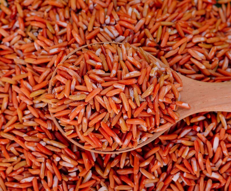 Red Rice in a Wooden Spoon on Red Rice Background Stock Photo - Image ...