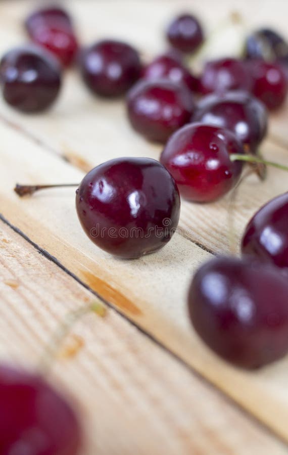 Red Ripe Cherries with Tails on a Wooden Background. the Side View is ...