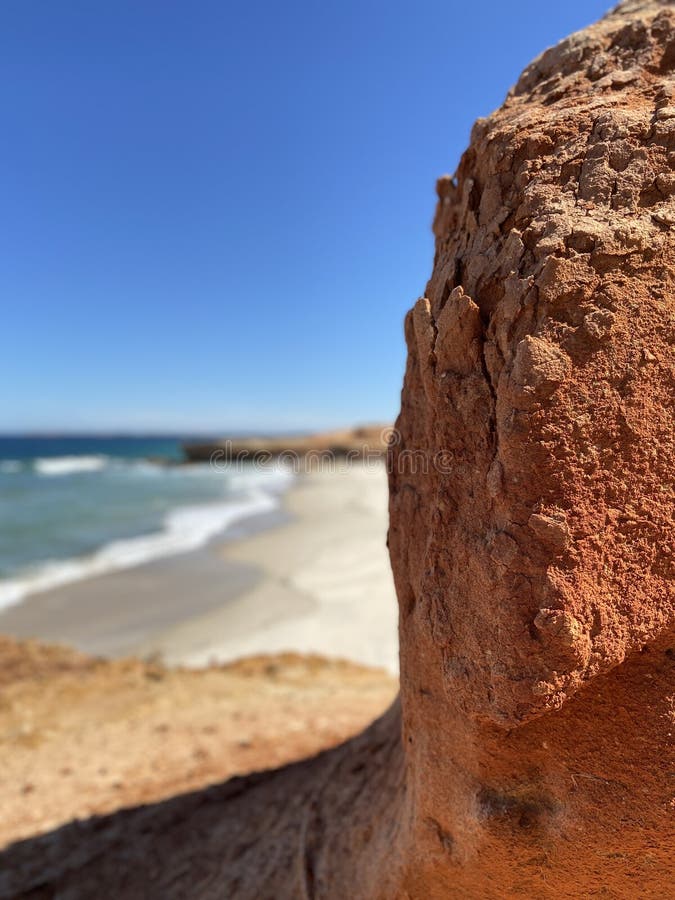 Red rock on beach stock image. Image of south, white - 177577893