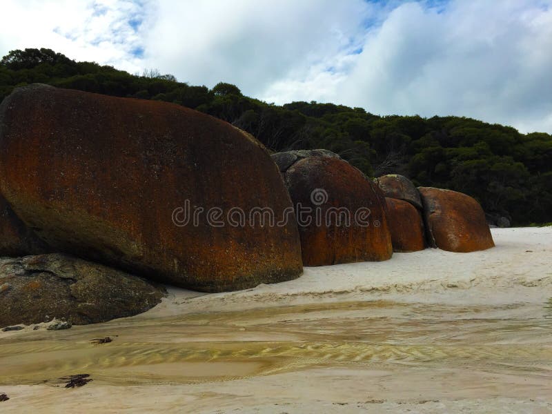 Red rocks at Squeaky beach stock photo. Image of rocks - 61842136