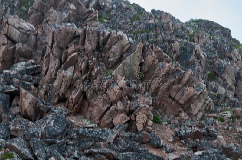 Red Rocky Slope of a Cliff Covered in Places with Moss and Grass Stock ...
