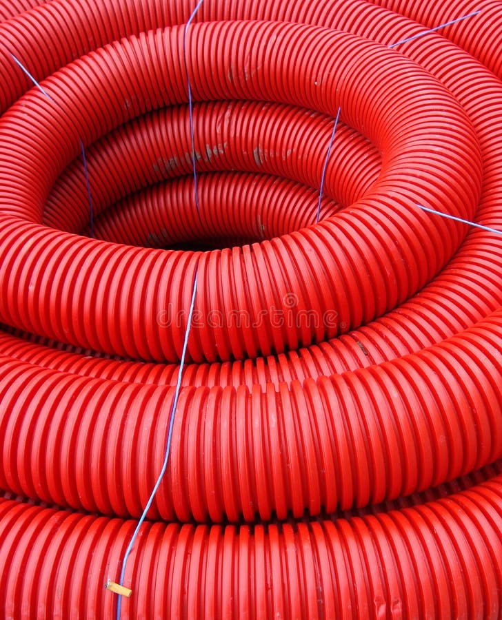 Red Rolled Up Wire Pipe on an Industrial Construction Site Stock Photo ...