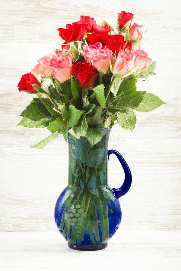 Red Roses in a Blue Vase on a Background of Vintage Boards Stock Photo ...