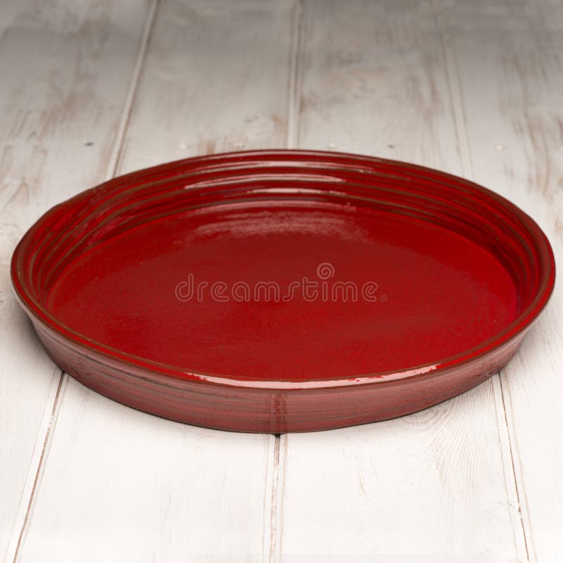 Red Round Shallow Dish on White Wooden Panel Surface Stock Photo ...