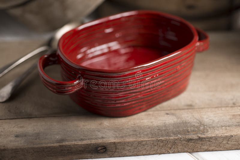 Red Rounded Rectangular Deep Dish and Utensils on Wooden Counter Stock ...