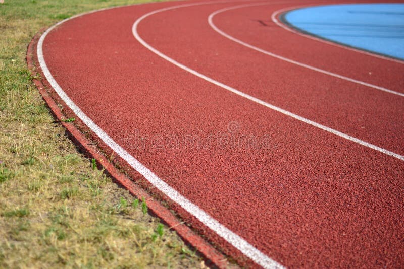 Red Running Track with Grass in Left Side and Blue Sports Field Stock ...