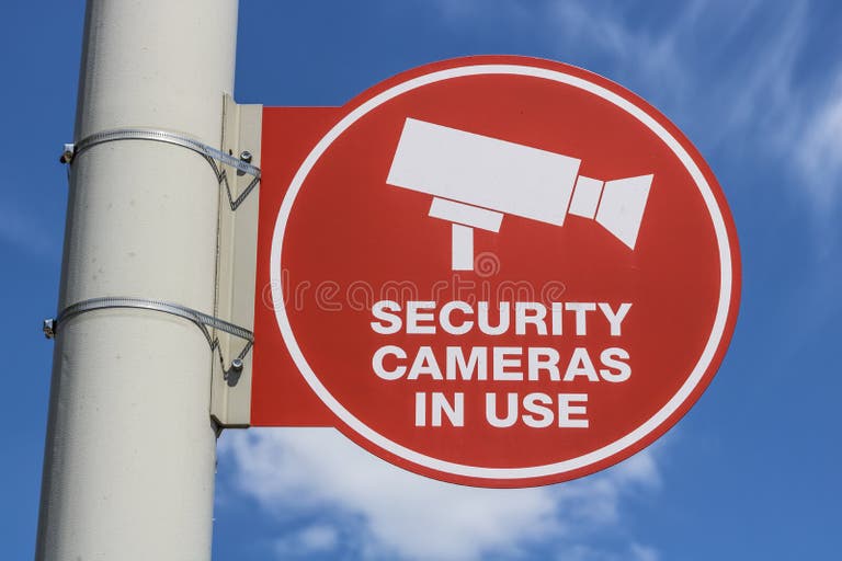 Red Security Camera in Use Sign on Gray Post and Mostly Sunny ...