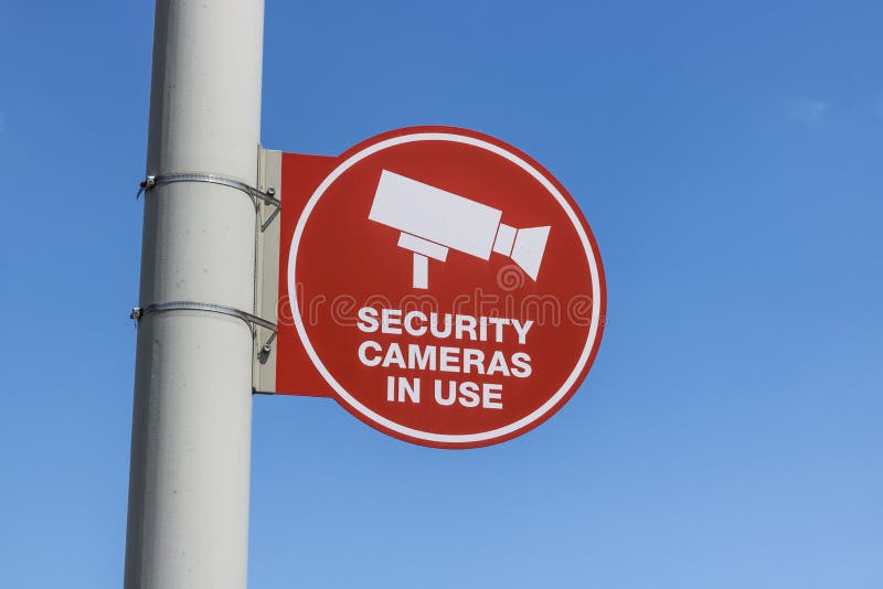 Red Security Camera in Use Sign on Gray Post and Mostly Sunny ...