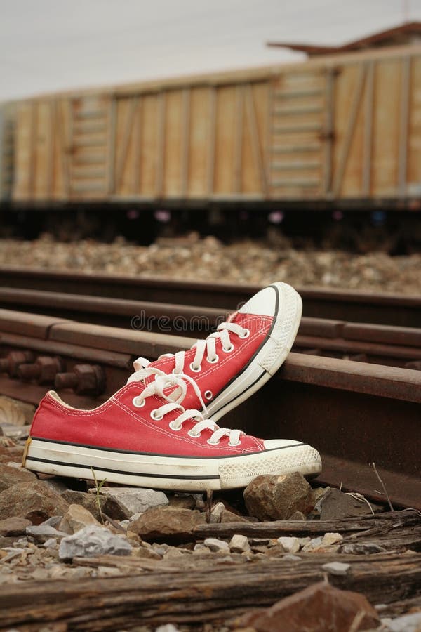 Red Shoes Leaning on the Train Tracks. Stock Photo - Image of jeans ...