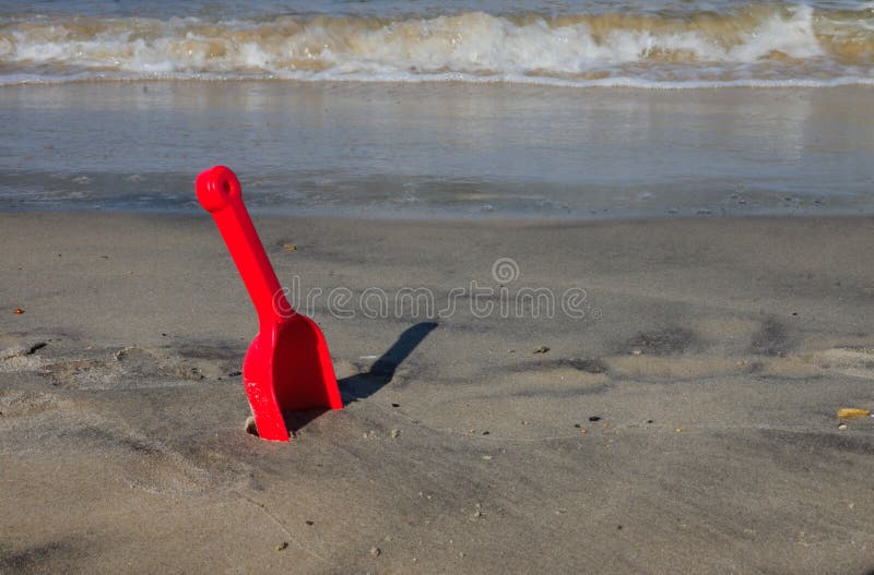 Red shovel at the beach stock photo. Image of holidays - 28451334