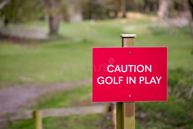 A Red Sign Next To a Golf Course Reading Caution Gold in Play Stock ...