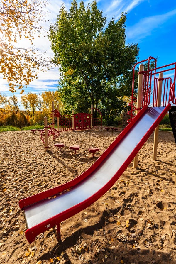 A Red and Silver Playground Slide is in a Park Stock Image - Image of ...