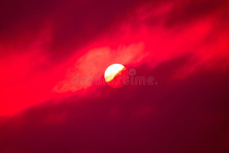 Isolated Red Background and Sun Behind the Clouds Stock Image - Image ...