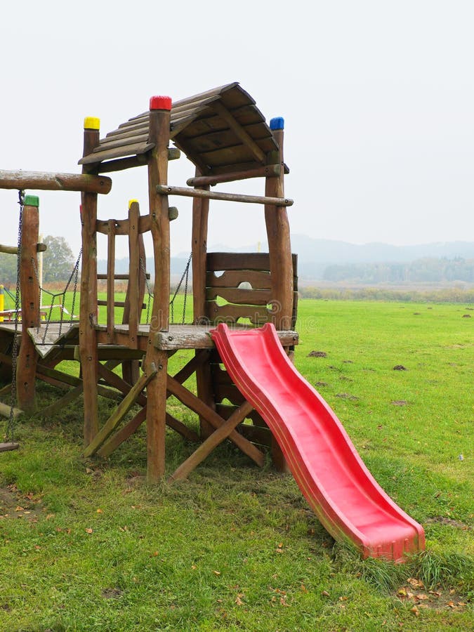 Red Slide from Wooden Crawl Construction on Modern Kids Playground ...