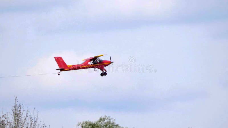 Red Small Sport Plane Flying in the Sky Pulls on a Rope the Glider ...