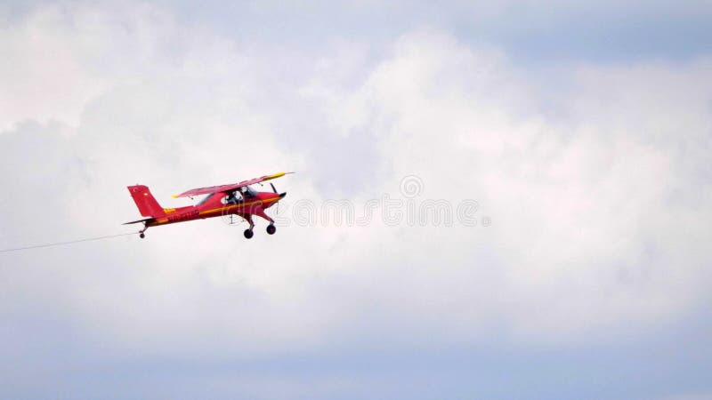 Red Small Sport Plane Flying in the Sky Pulls on a Rope the Glider ...