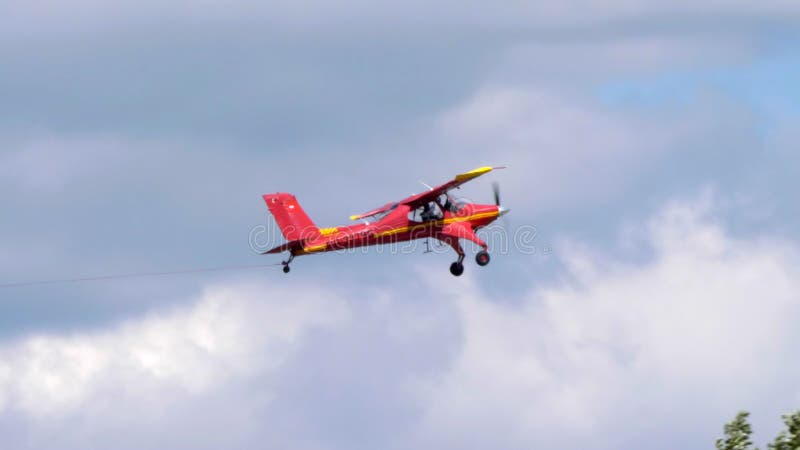 Red Small Sport Plane Flying in the Sky Pulls on a Rope the Glider ...