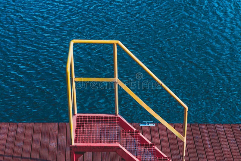 Red Stairs with a Yellow Railing Leading To the Pier Stock Photo ...