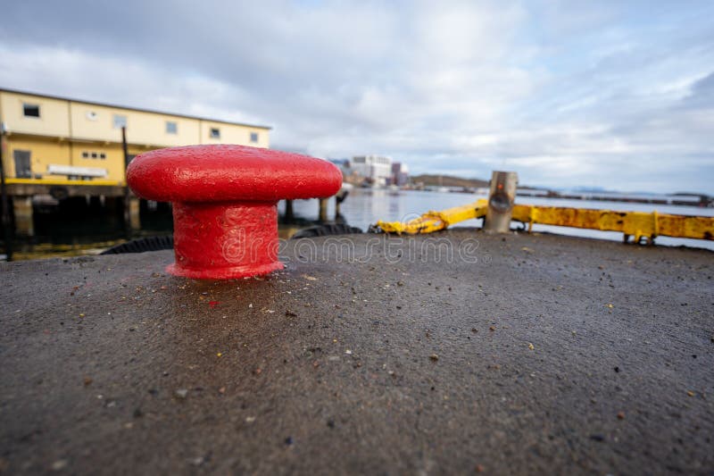 Red Steel Bollard at the Harbor with a Sea View in the Background Stock ...