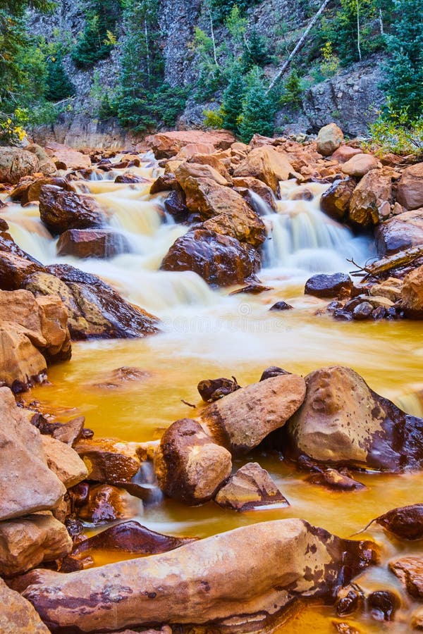 Red Stones Along Golden River with Cascading Waterfalls Stock Photo ...