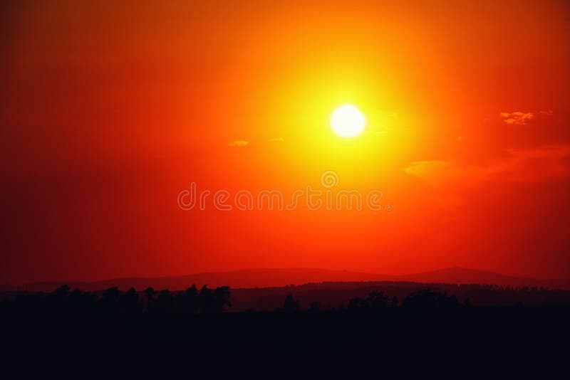 Red Sunset with Light Clouds and Silhouette of Hills and Trees Stock ...