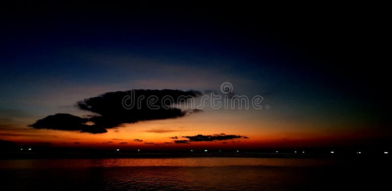 Red Sunset Ocean with Lights in the Far Stock Image - Image of ocean ...