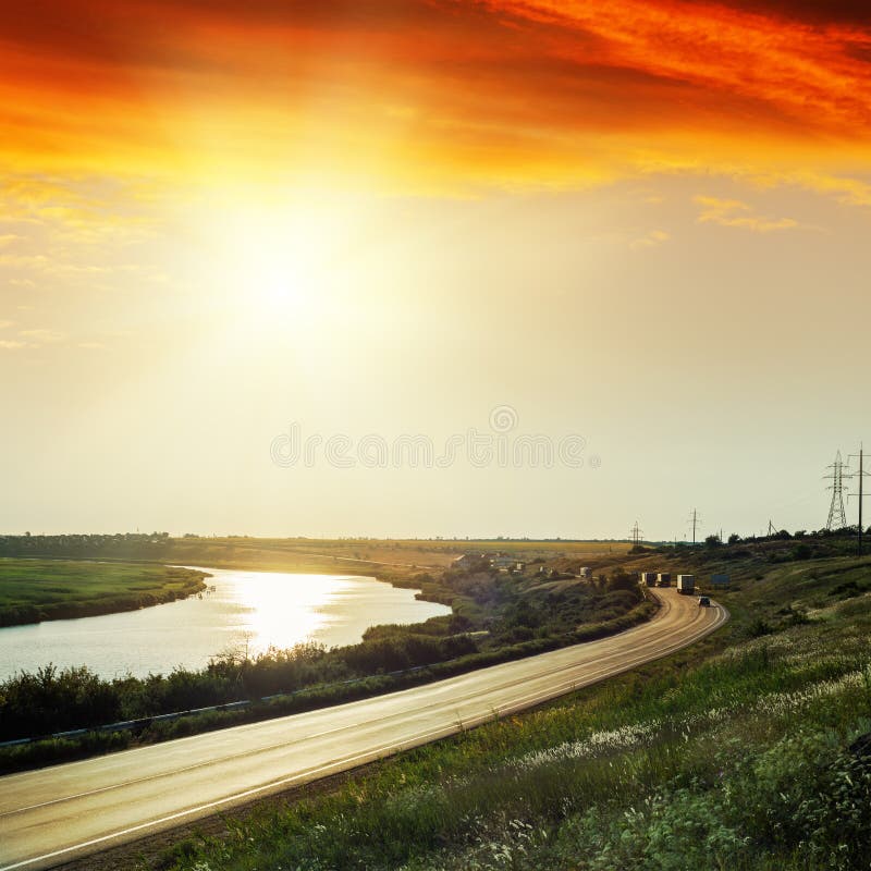 Red Sunset Over Asphalt Road Near River Stock Photo - Image of grass ...