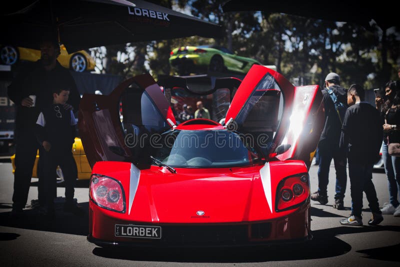 Red Superlite Car with Open Doors with People in the Background ...