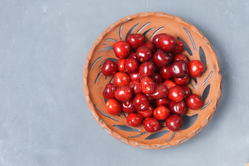 Red Sweet Cherry in a Clay Plate on a Gray Table Stock Image - Image of ...