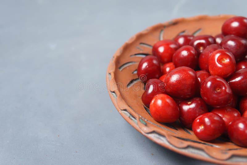 Red Sweet Cherry in a Clay Plate on a Gray Table Stock Image - Image of ...