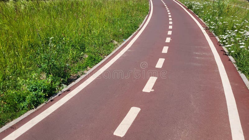 A Red Synthetic Treadmill or Bicycle Path with White Markings, with a ...