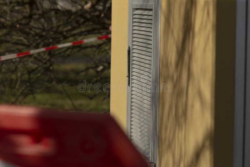 A Red Telephone is by a Window on the Side of a Building Stock Photo ...