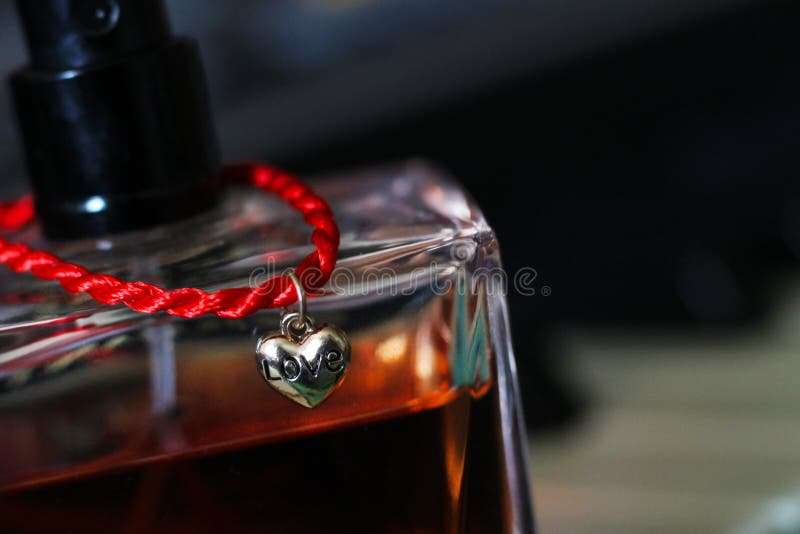 Red Thread with Gold Heart Pendant and Women`s Perfume Stock Image ...