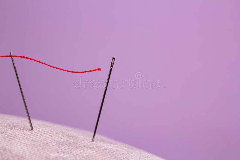 Red Thread for Sewing is Threaded into the Eye of the Needle and ...