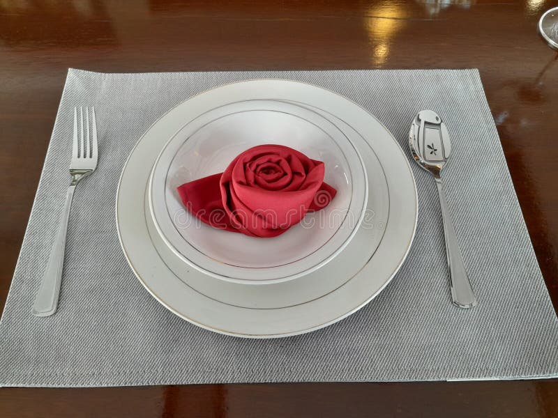 Red Tissue with the Shape of a Rose Placed on a Plate on the Dining ...