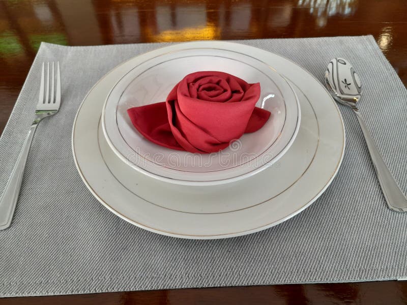 Red Tissue with the Shape of a Rose Placed on a Plate on the Dining ...